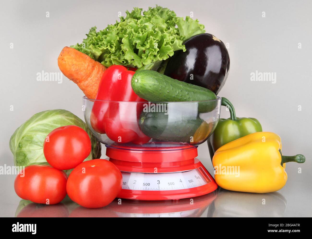 Fresh vegetables in scales on gray background Stock Photo - Alamy