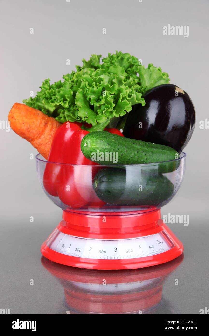 Fresh vegetables in scales on gray background Stock Photo - Alamy
