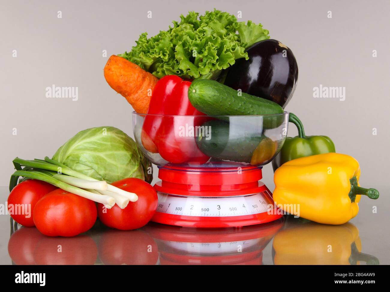 Fresh vegetables in scales on gray background Stock Photo - Alamy