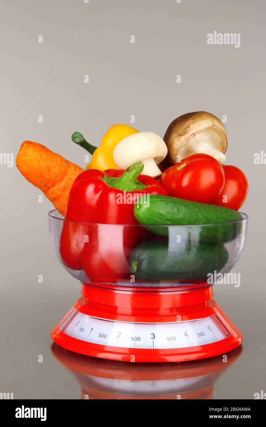 Fresh vegetables in scales on gray background Stock Photo - Alamy