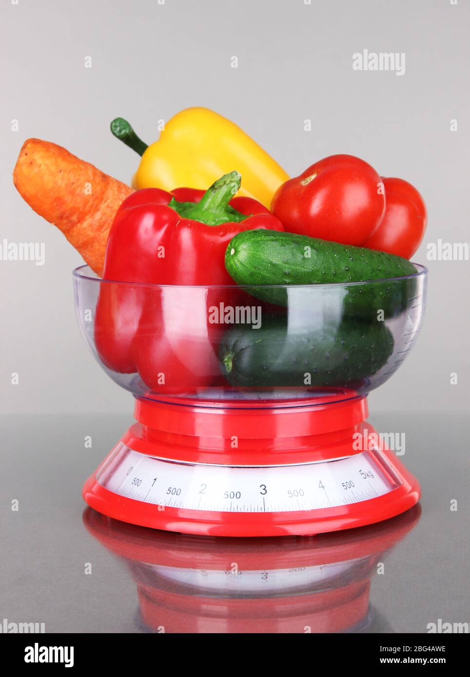 Fresh vegetables in scales on gray background Stock Photo - Alamy