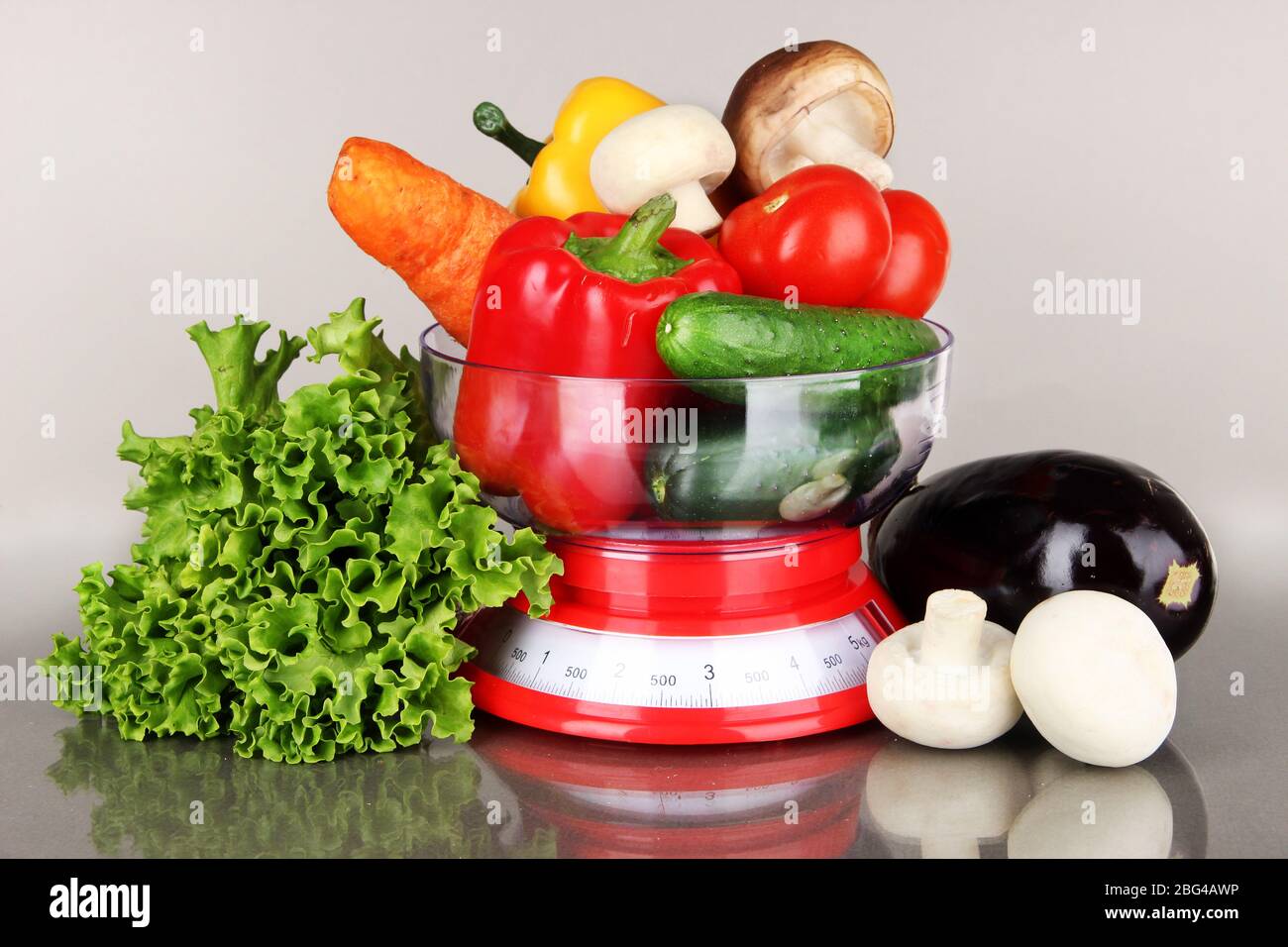 Fresh vegetables in scales on gray background Stock Photo - Alamy