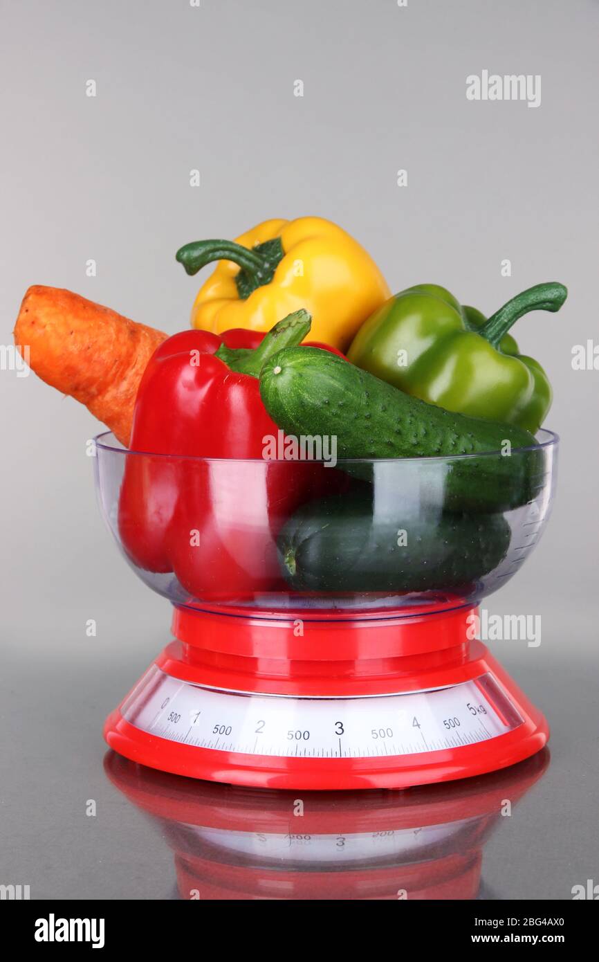 Fresh vegetables in scales on gray background Stock Photo - Alamy