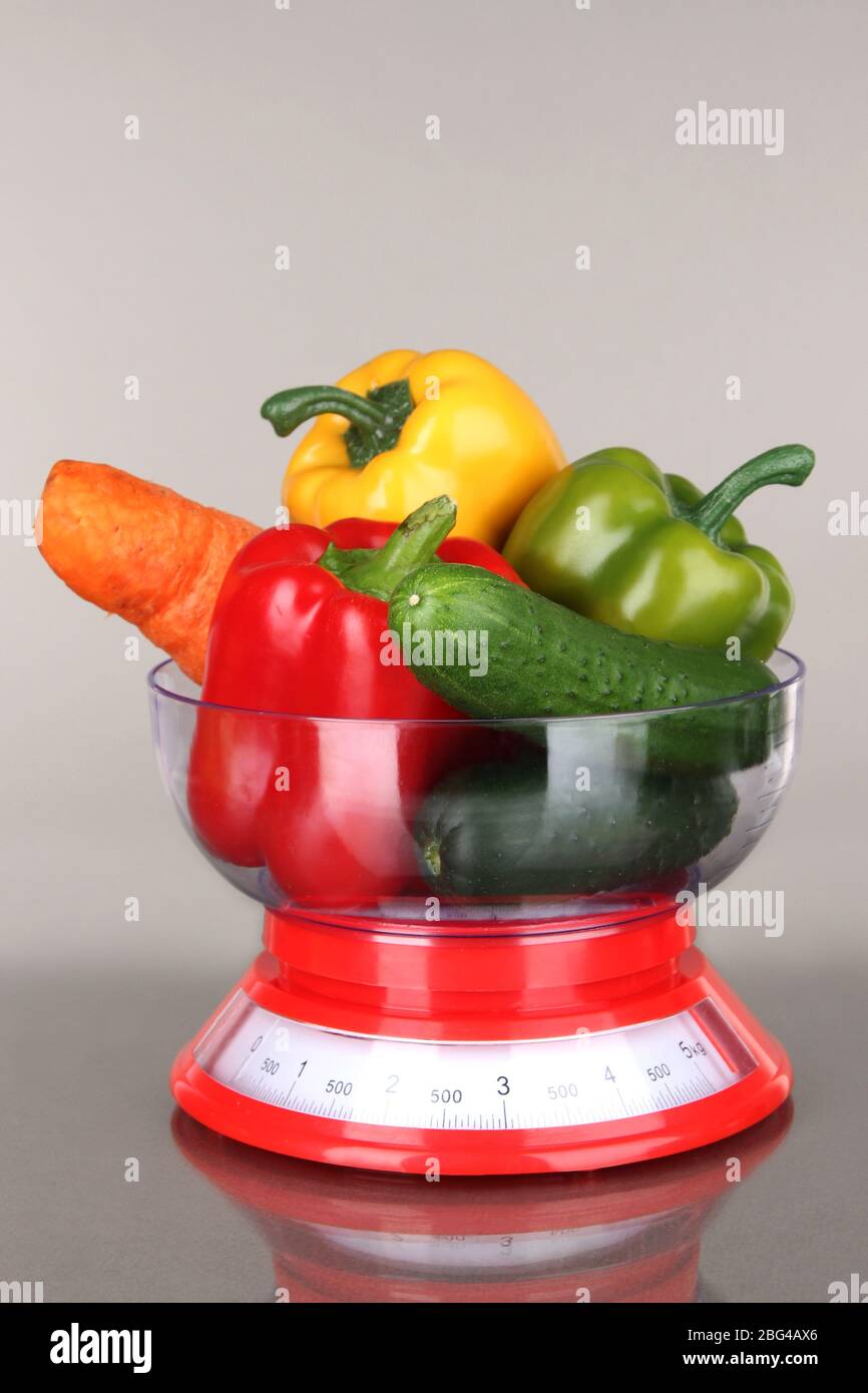 Fresh vegetables in scales on gray background Stock Photo - Alamy