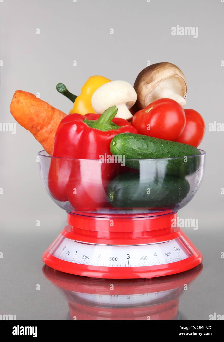 Fresh vegetables in scales on gray background Stock Photo - Alamy