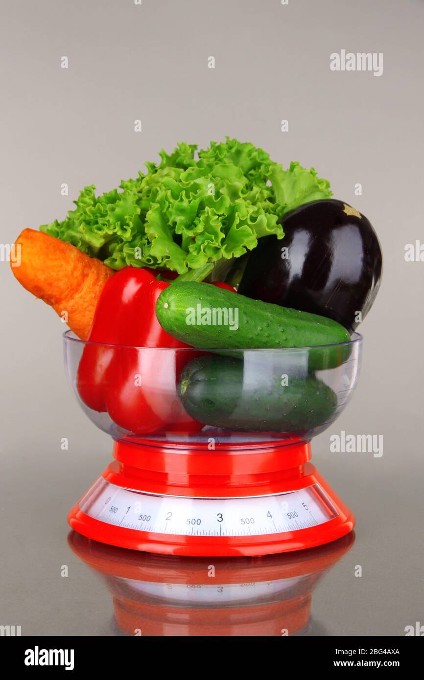 Fresh vegetables in scales on gray background Stock Photo - Alamy