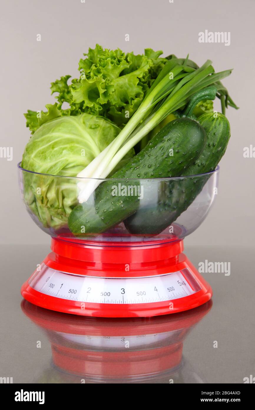 Fresh vegetables in scales on gray background Stock Photo - Alamy