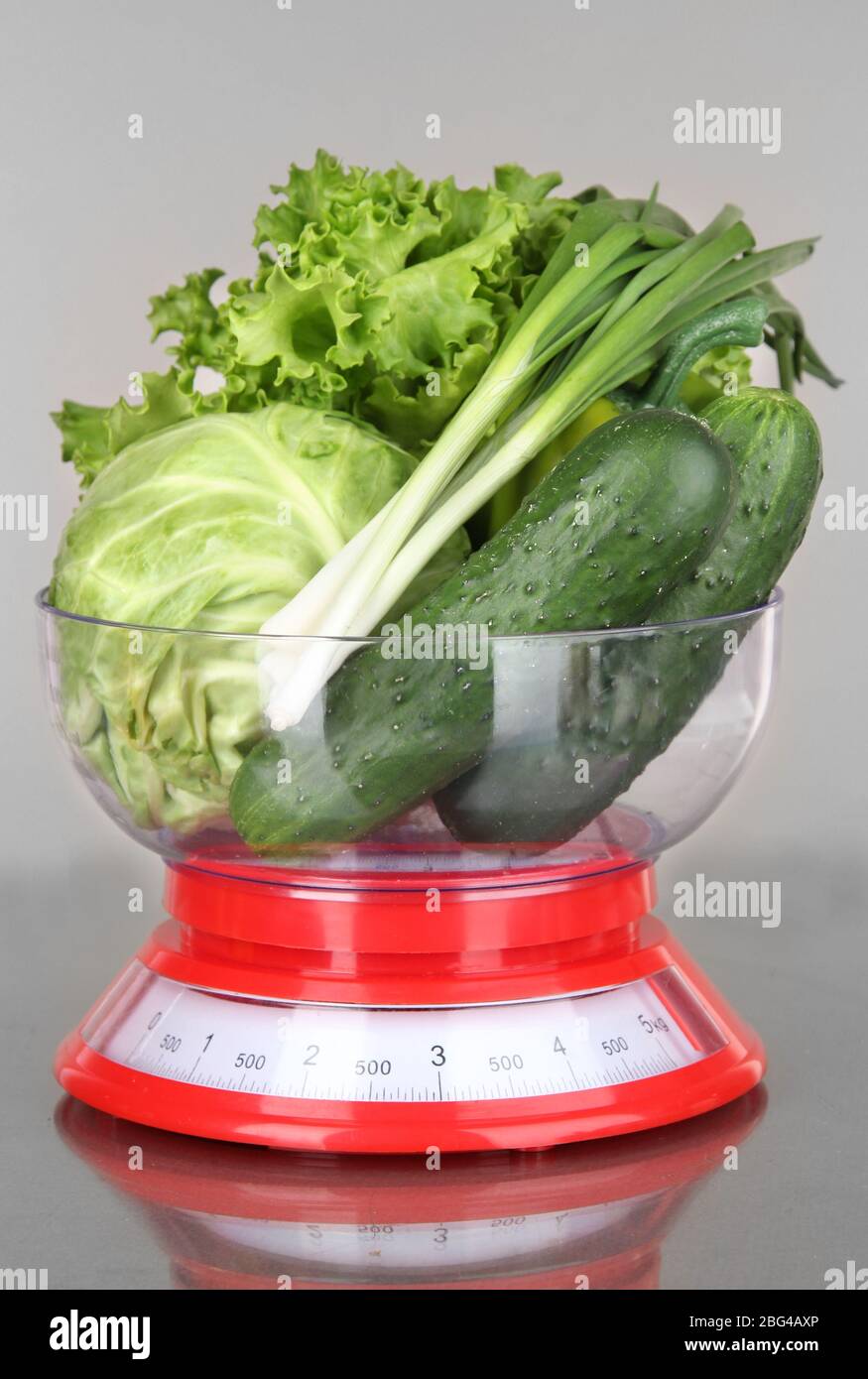 Fresh vegetables in scales on gray background Stock Photo - Alamy