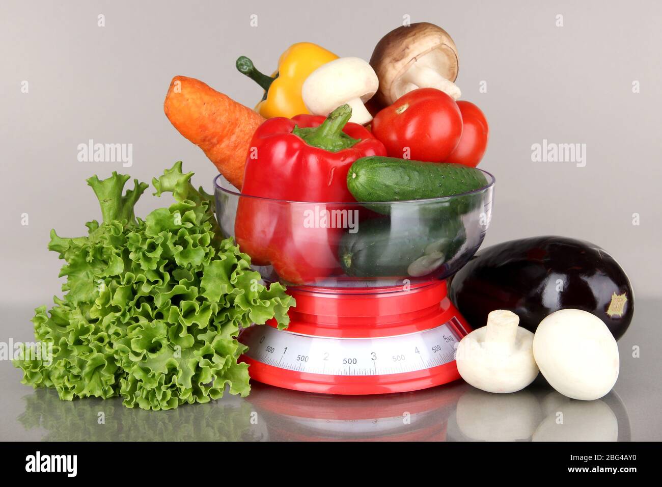 Fresh vegetables in scales on gray background Stock Photo - Alamy