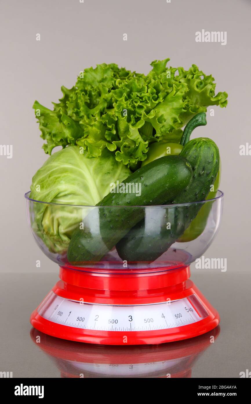 Fresh vegetables in scales on gray background Stock Photo - Alamy