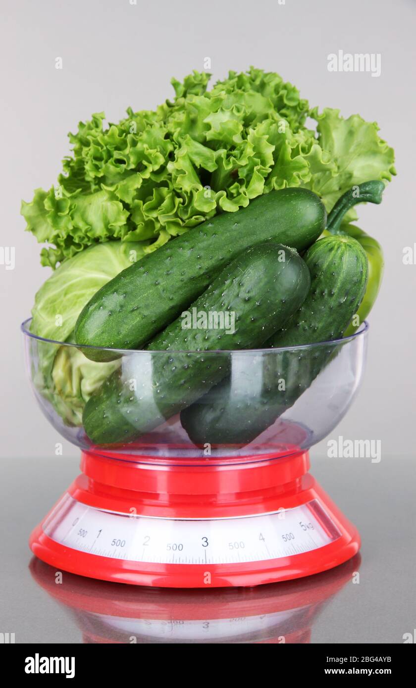 Fresh vegetables in scales on gray background Stock Photo - Alamy