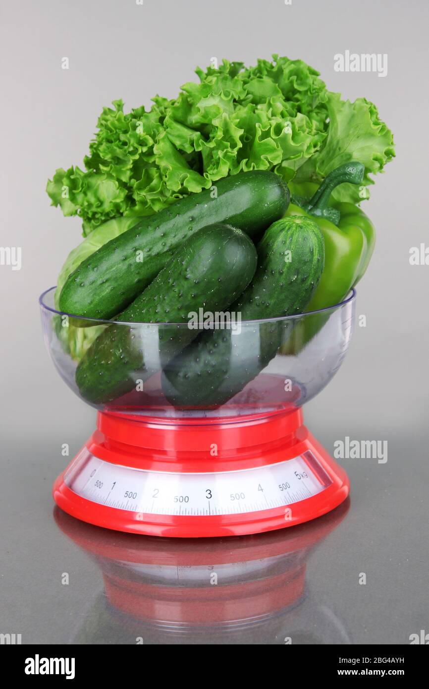 Fresh vegetables in scales on gray background Stock Photo - Alamy