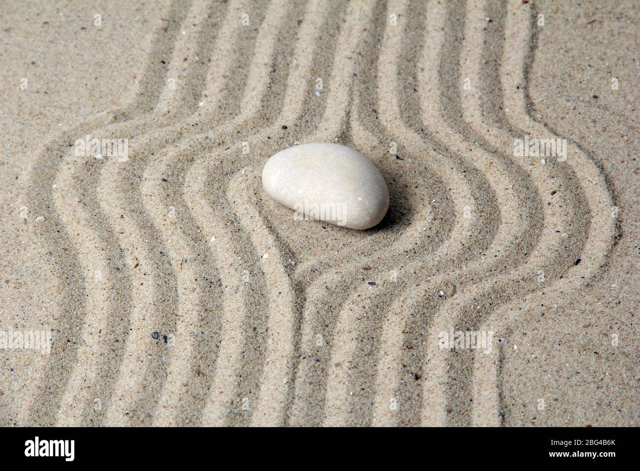 Zen garden with raked sand and round stone close up Stock Photo - Alamy