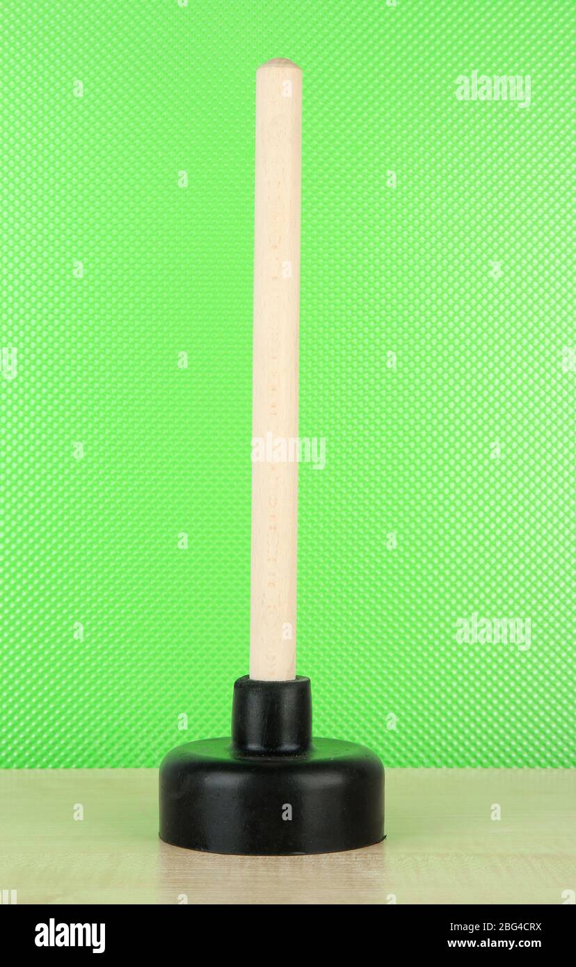 Toilet plunger on green background Stock Photo - Alamy