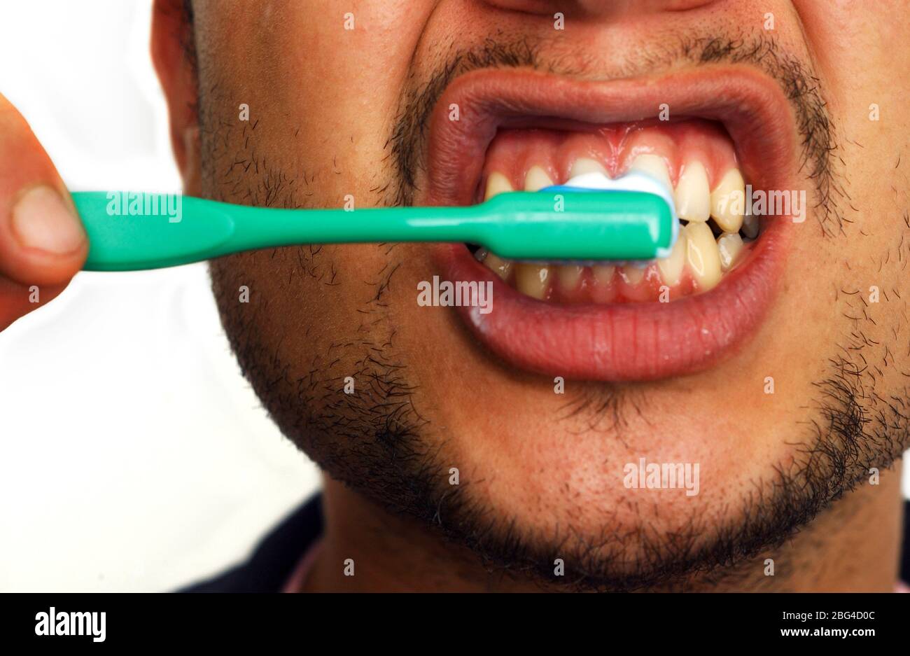 Close-up of a young man brushing his teeth. Regular brushing of teeth ...