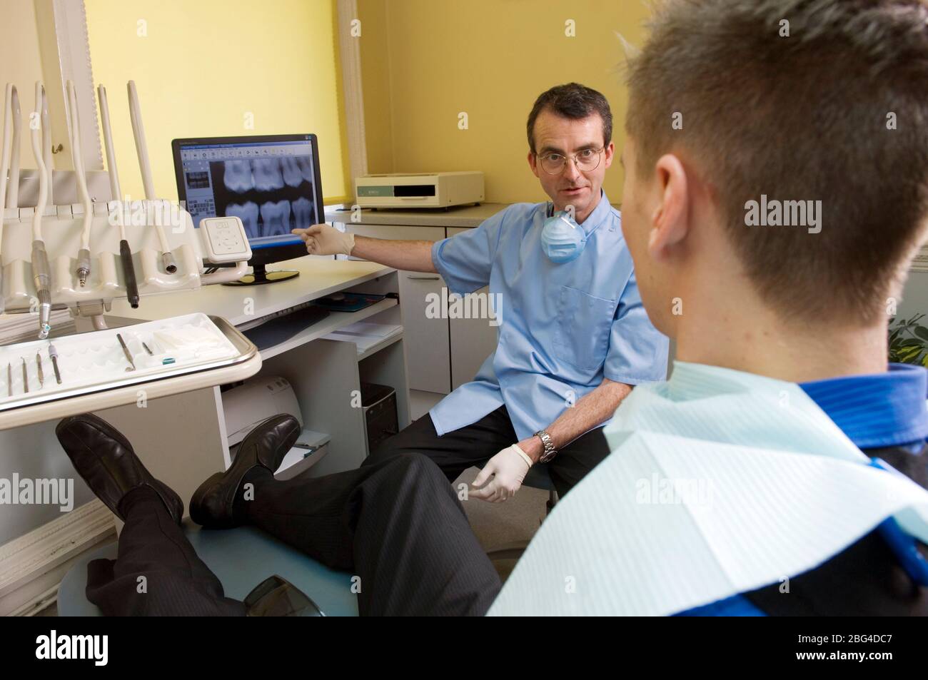 Dentist in front of a computer screen, discusses the results of an xray ...