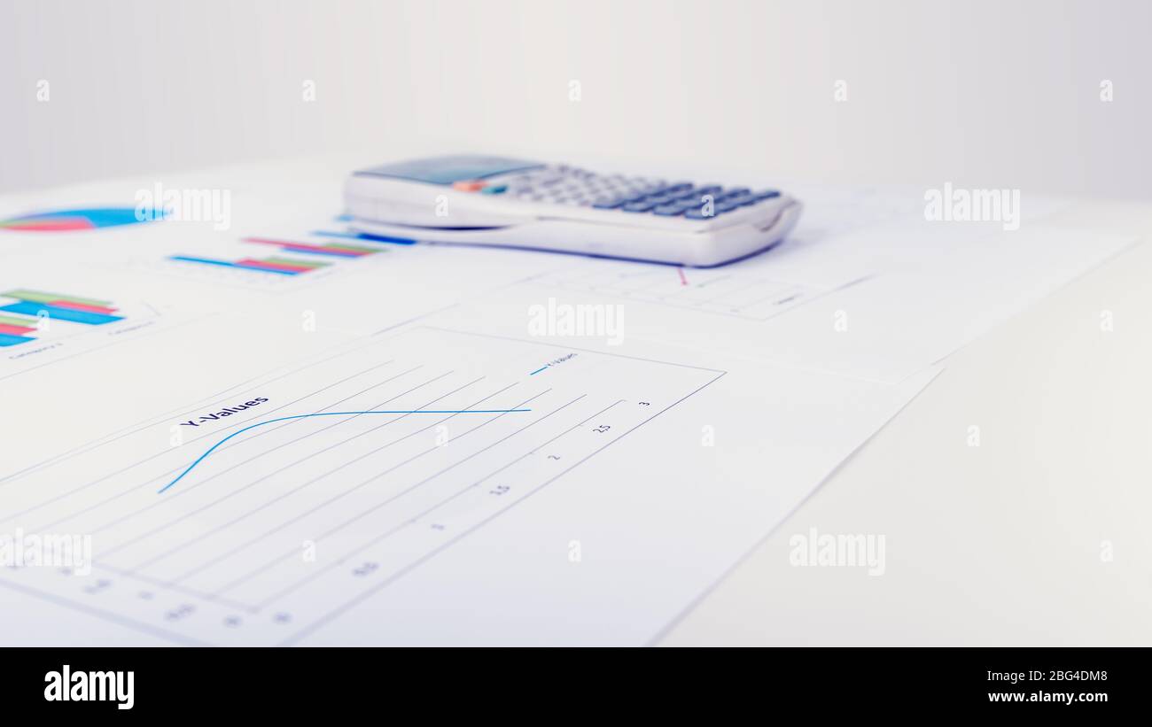 Desk calculator next to printed business documents with different ...
