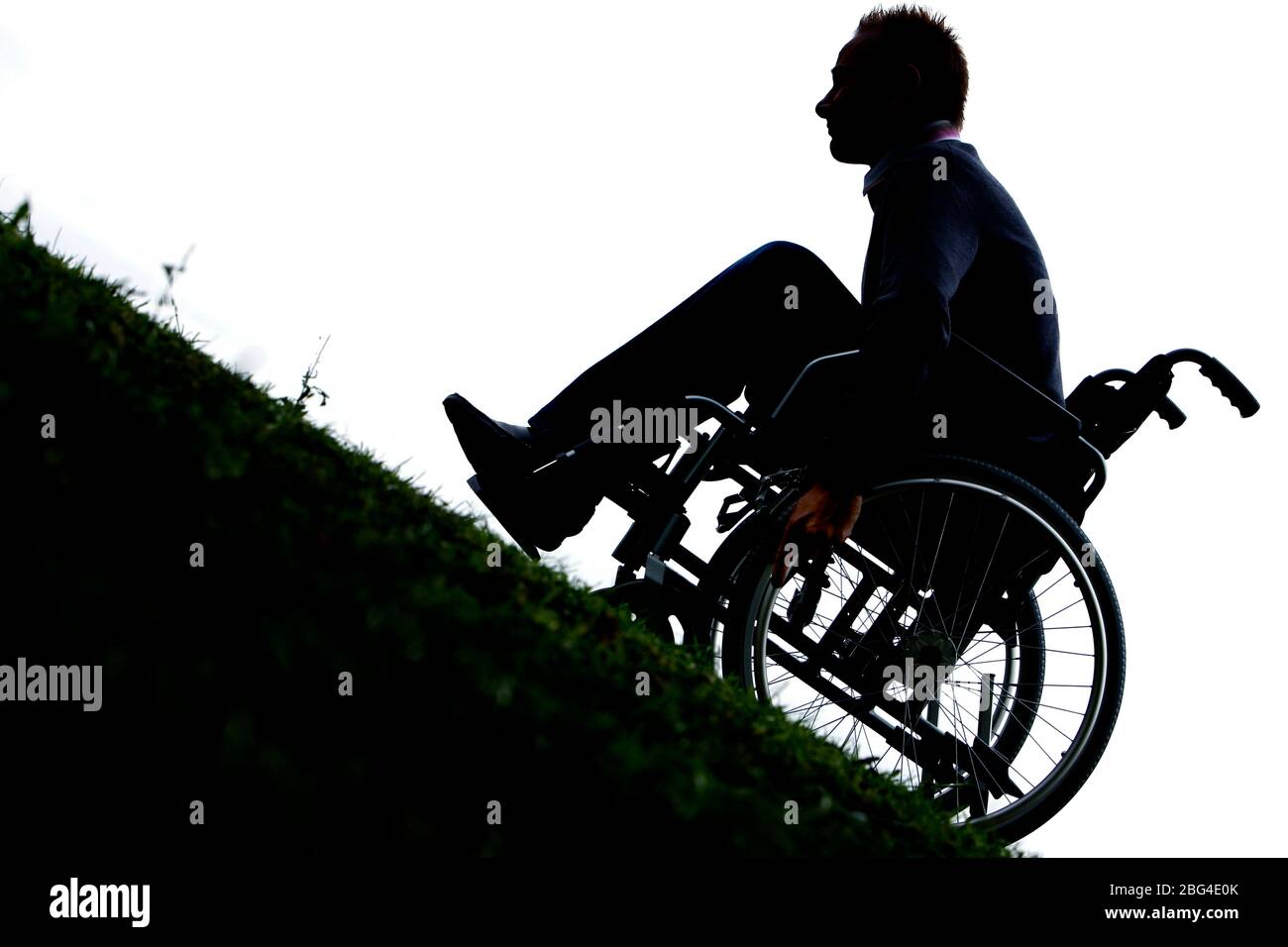 A Man Wheelchair bound, wheeling through a park Stock Photo - Alamy
