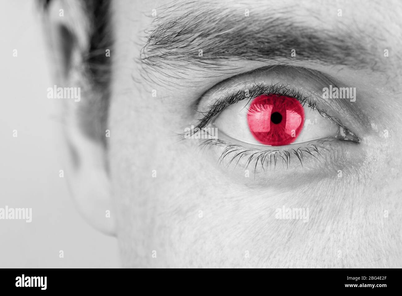 Monochrome image with selective color of a young man with red eye ...