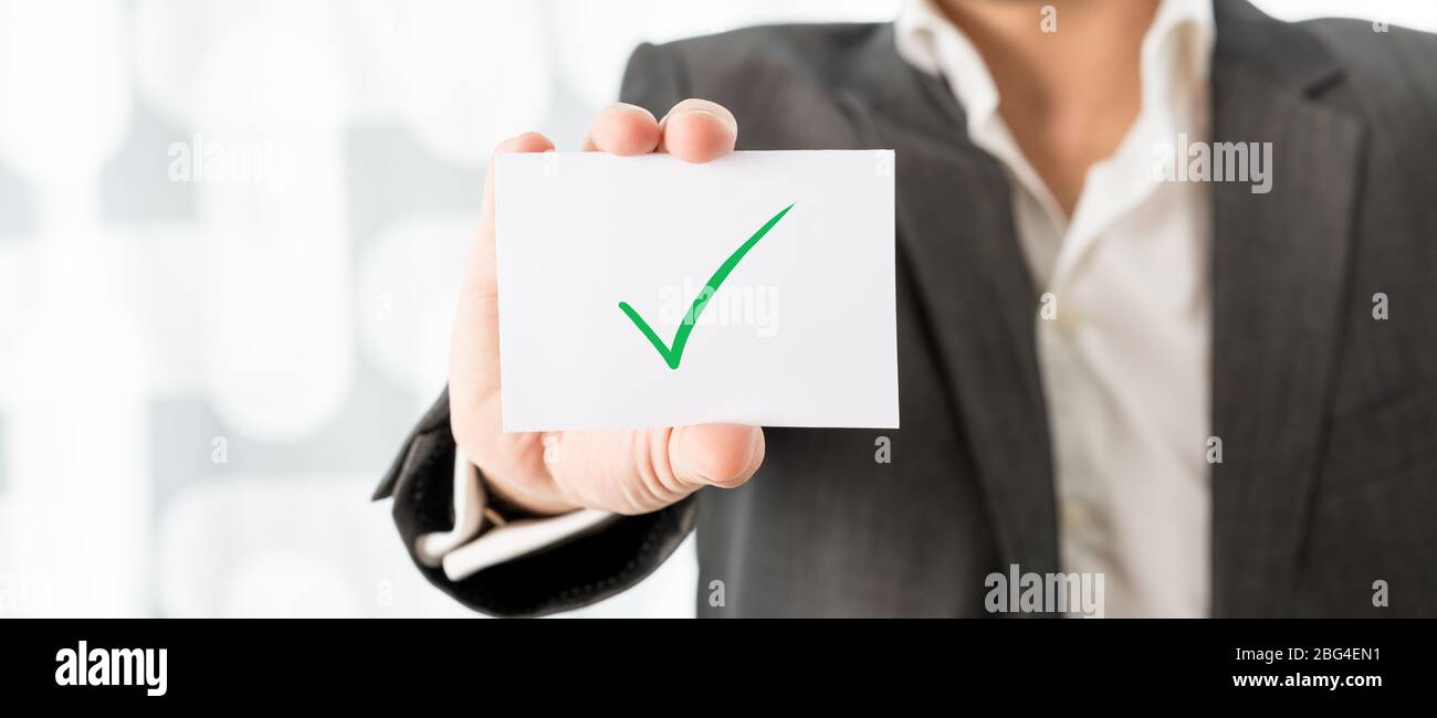 Closeup of businessman or teacher holding up a white card with green ...