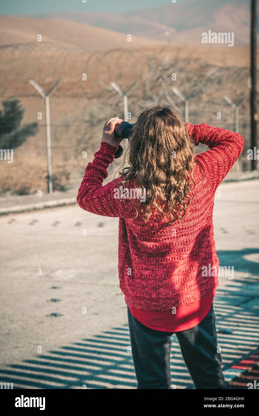 Back view teenage girl standing outdoor, looking forward with ...