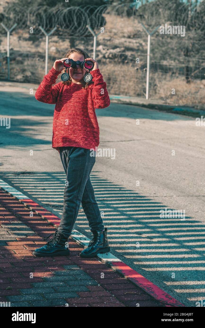 Blonde child standing outdoor, looking forward with binoculars Stock ...