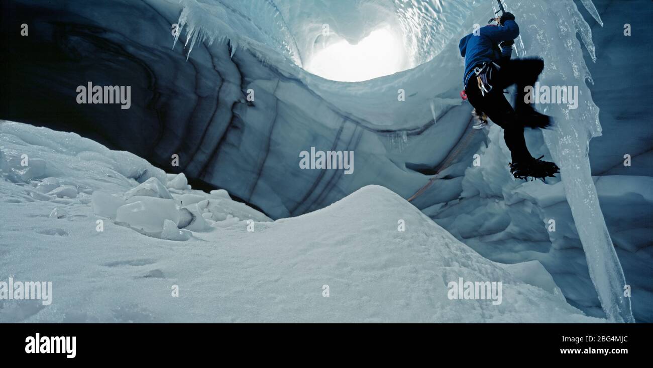 Ice climber scaling icicle in cave underneath Langjokull glacier Stock ...