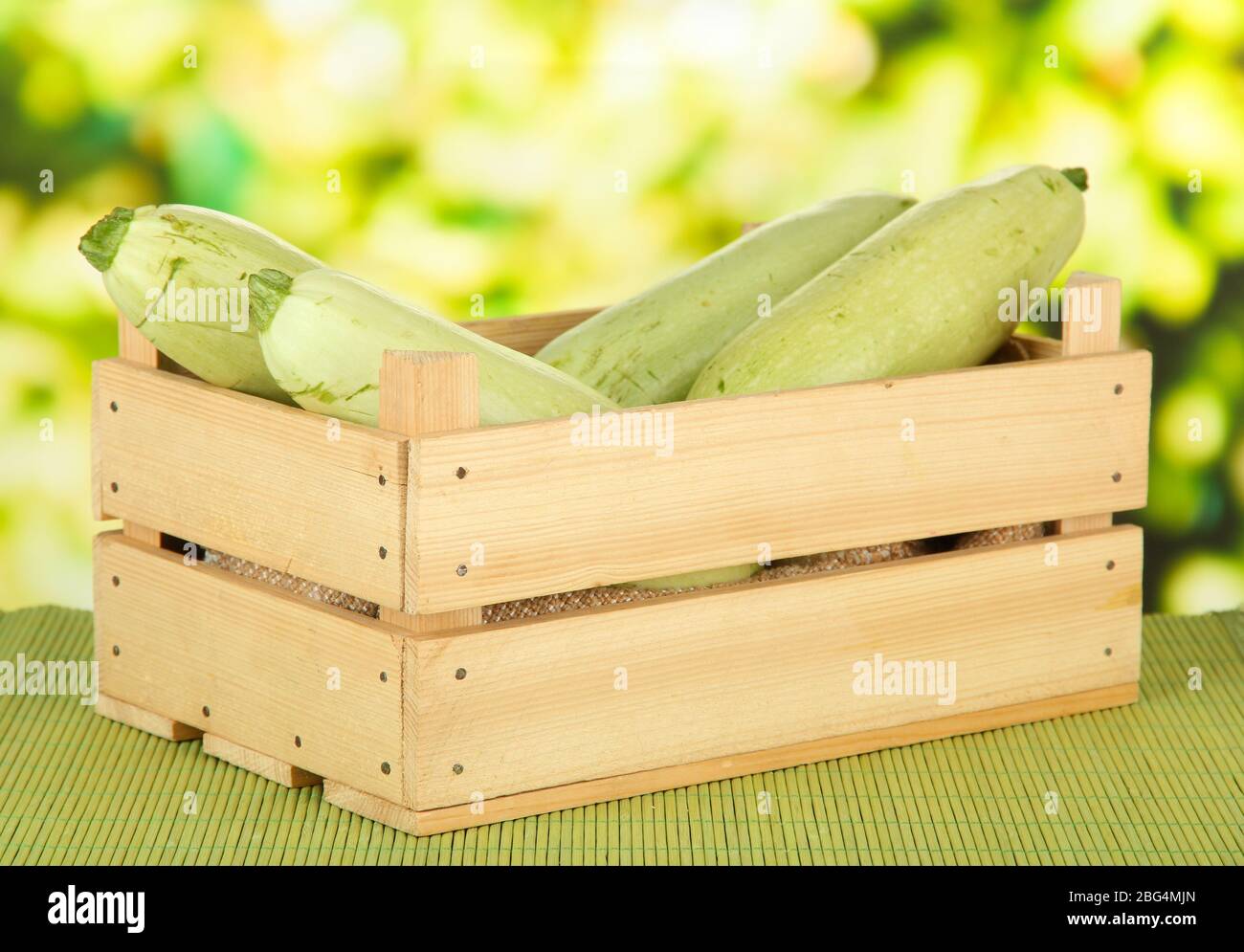 Fresh marrows in wooden box, on bamboo mat, on bright background Stock ...