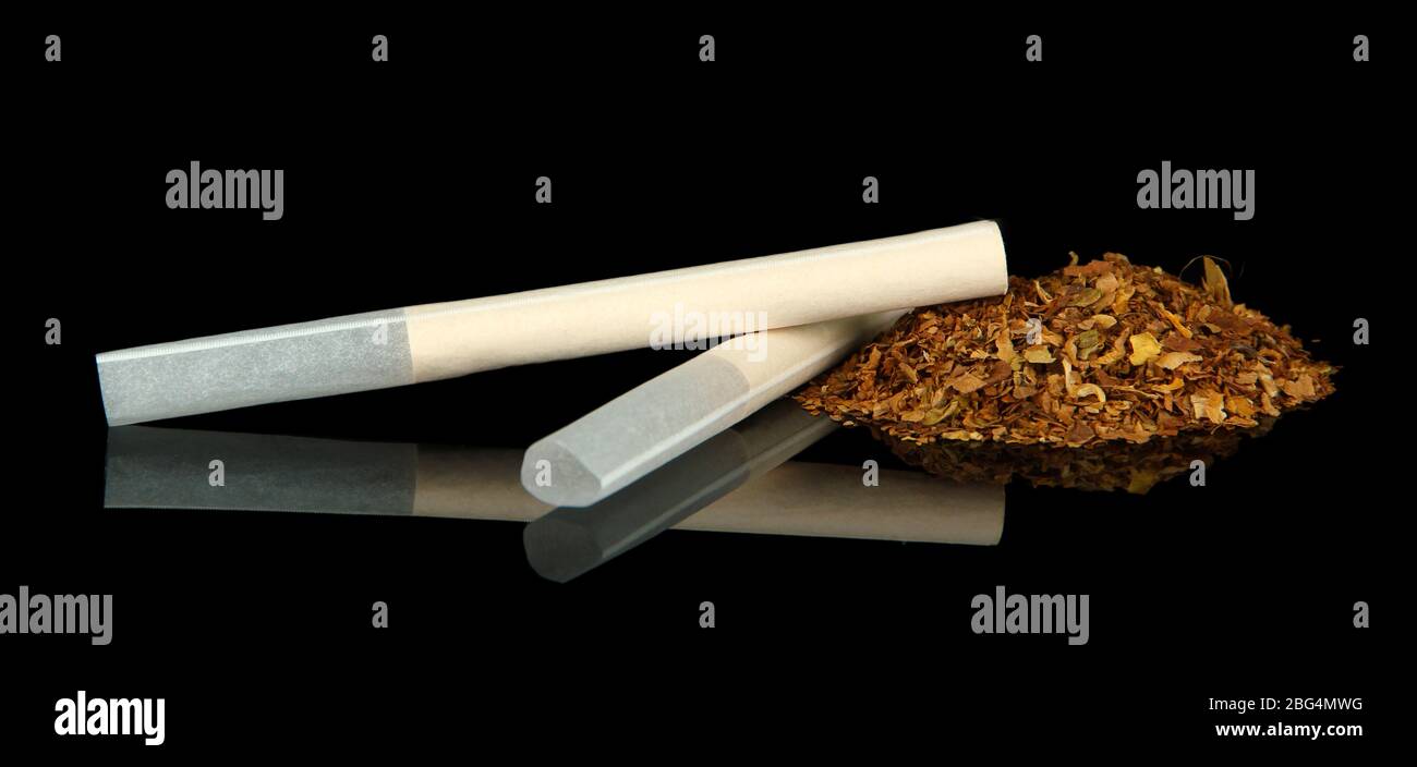 Tobacco and empty cigarette tubes, isolated on black Stock Photo - Alamy