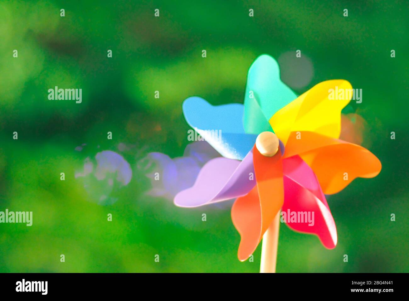 Colorful Pinwheel Toy Against green bokeh background of summer ...