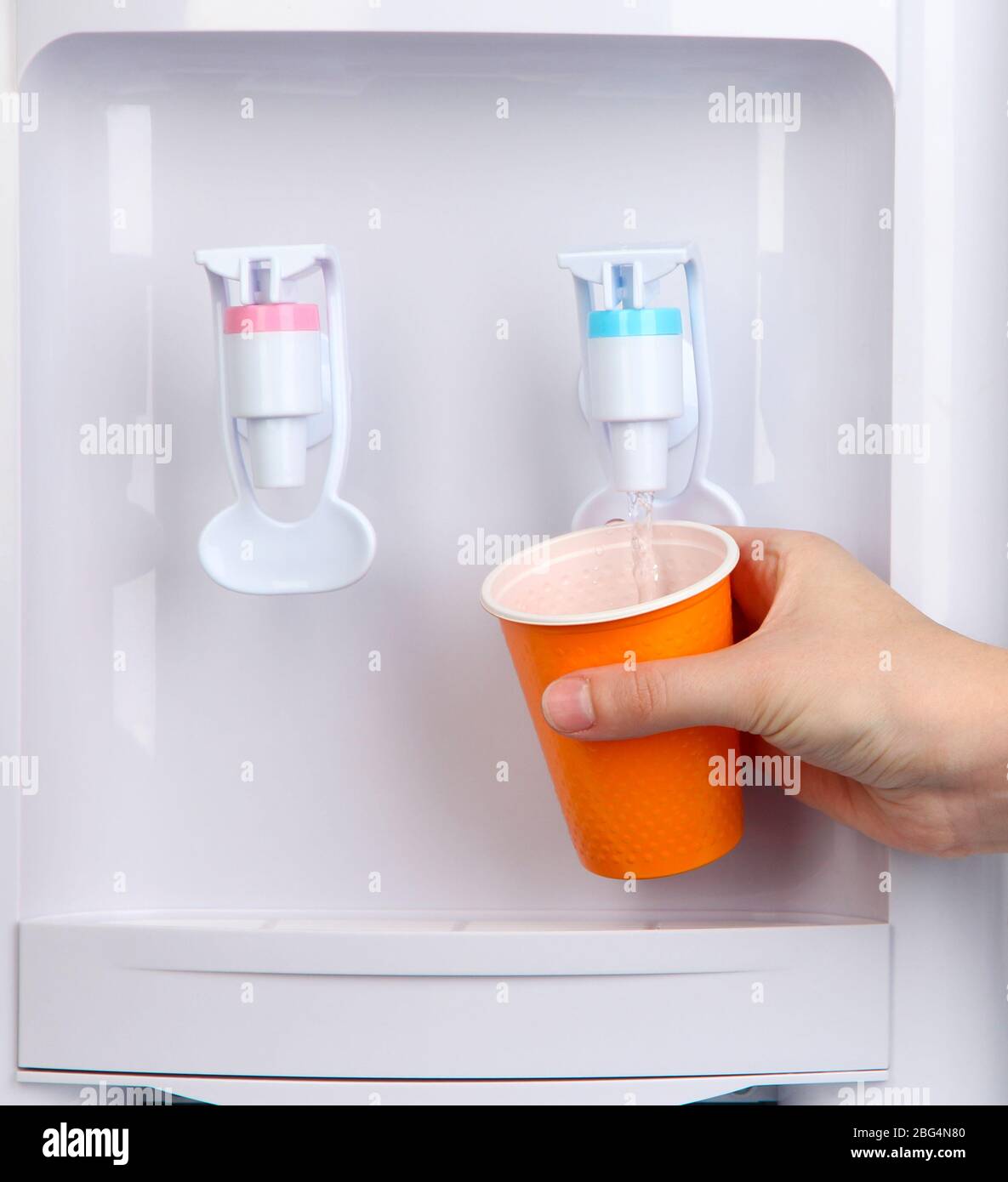 Woman filling cup at water cooler Stock Photo - Alamy