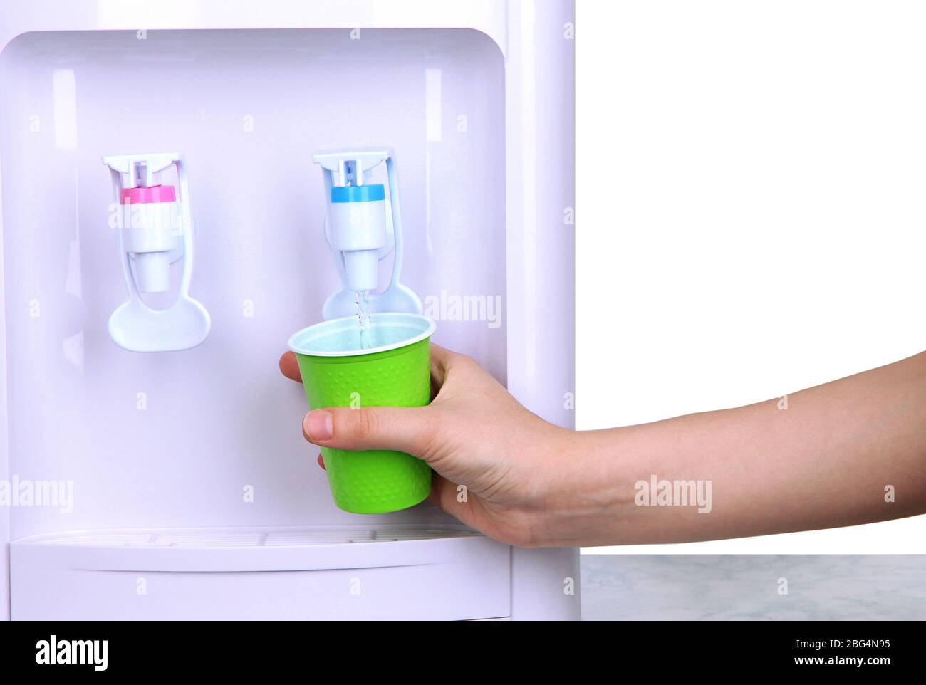 Woman filling cup at water cooler Stock Photo - Alamy