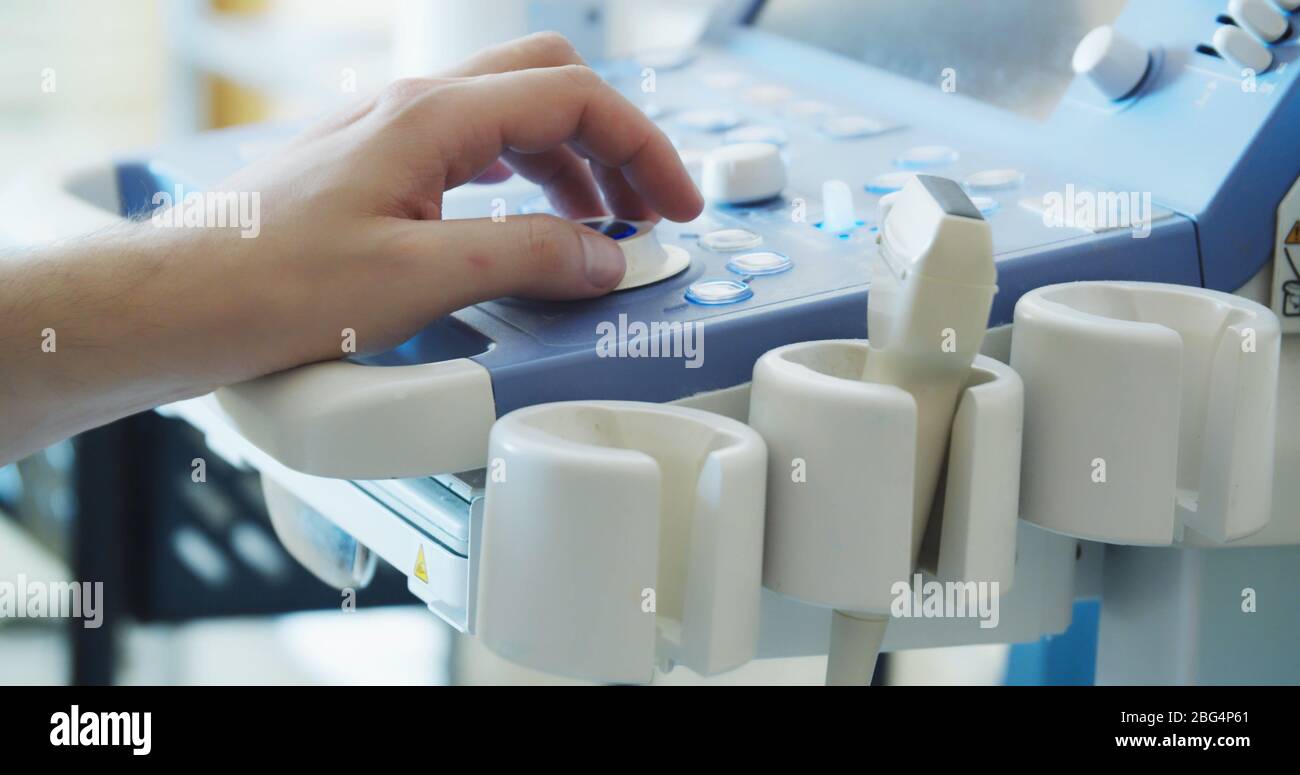 Sonographer operating ultrasound machine while scanning young pregnant ...