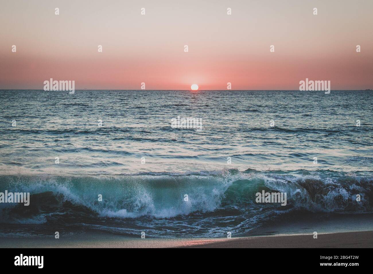 Beautiful sunset over waves pink hi-res stock photography and images ...