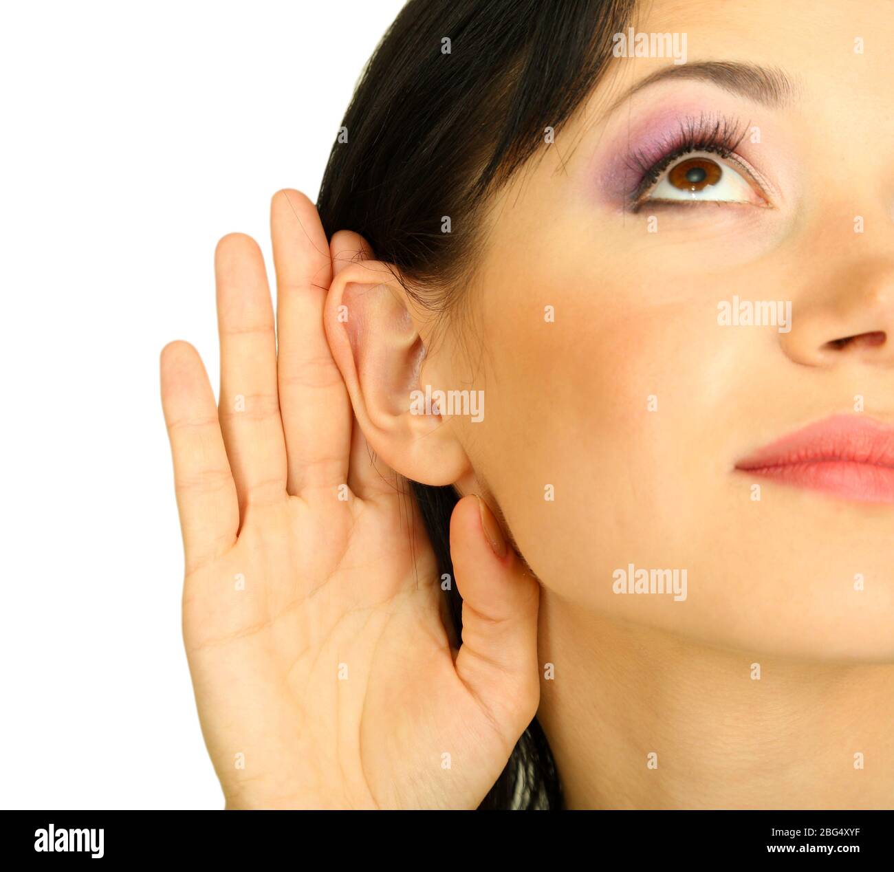 Girl overhears on grey background Stock Photo - Alamy