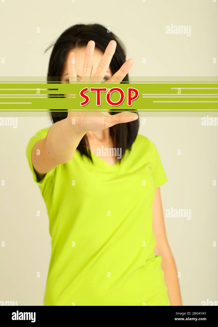 Girl showing stop sign on grey background Stock Photo - Alamy