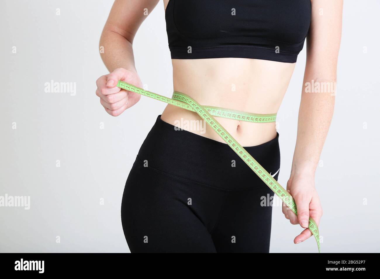 Beautiful young woman with measuring tape Stock Photo - Alamy