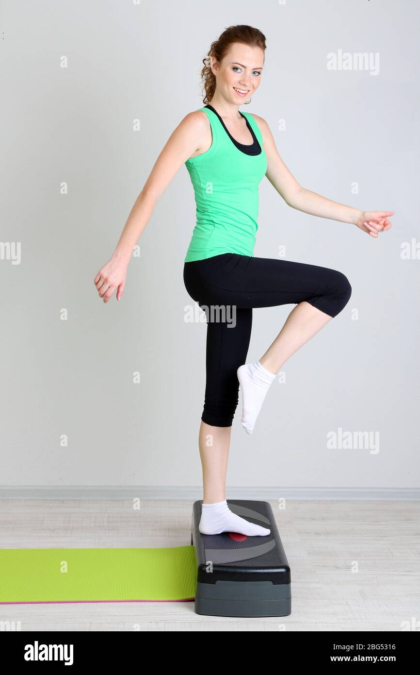Beautiful young woman exercises on stepper Stock Photo - Alamy