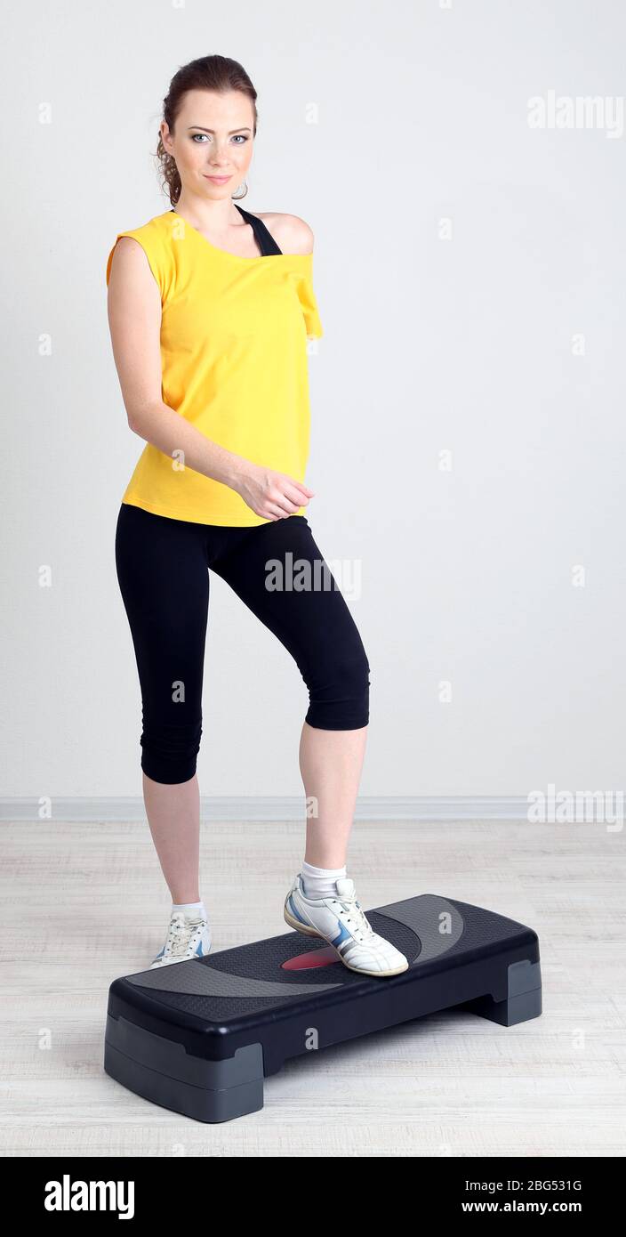 Beautiful young woman exercises on stepper Stock Photo - Alamy