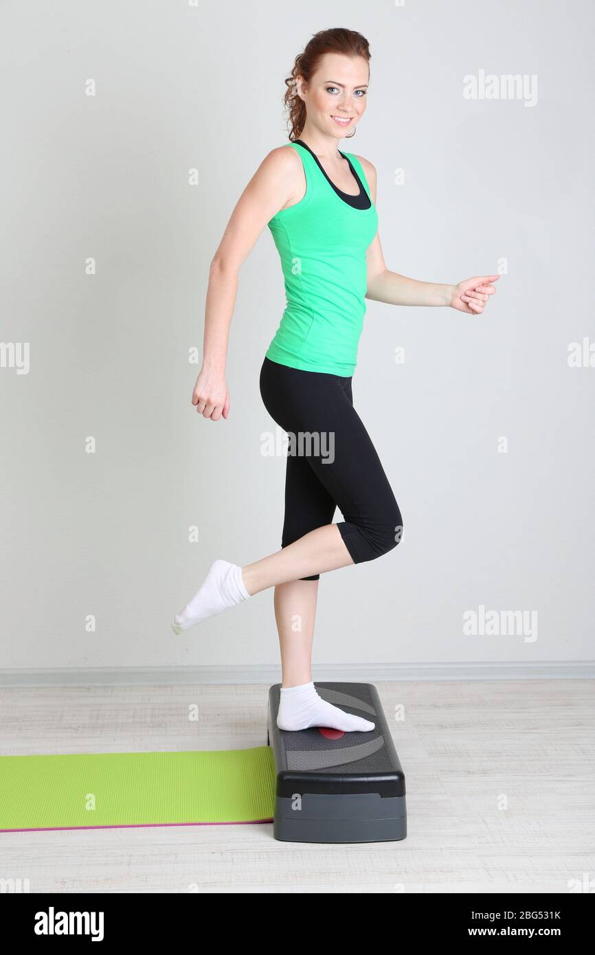Beautiful young woman exercises on stepper Stock Photo - Alamy