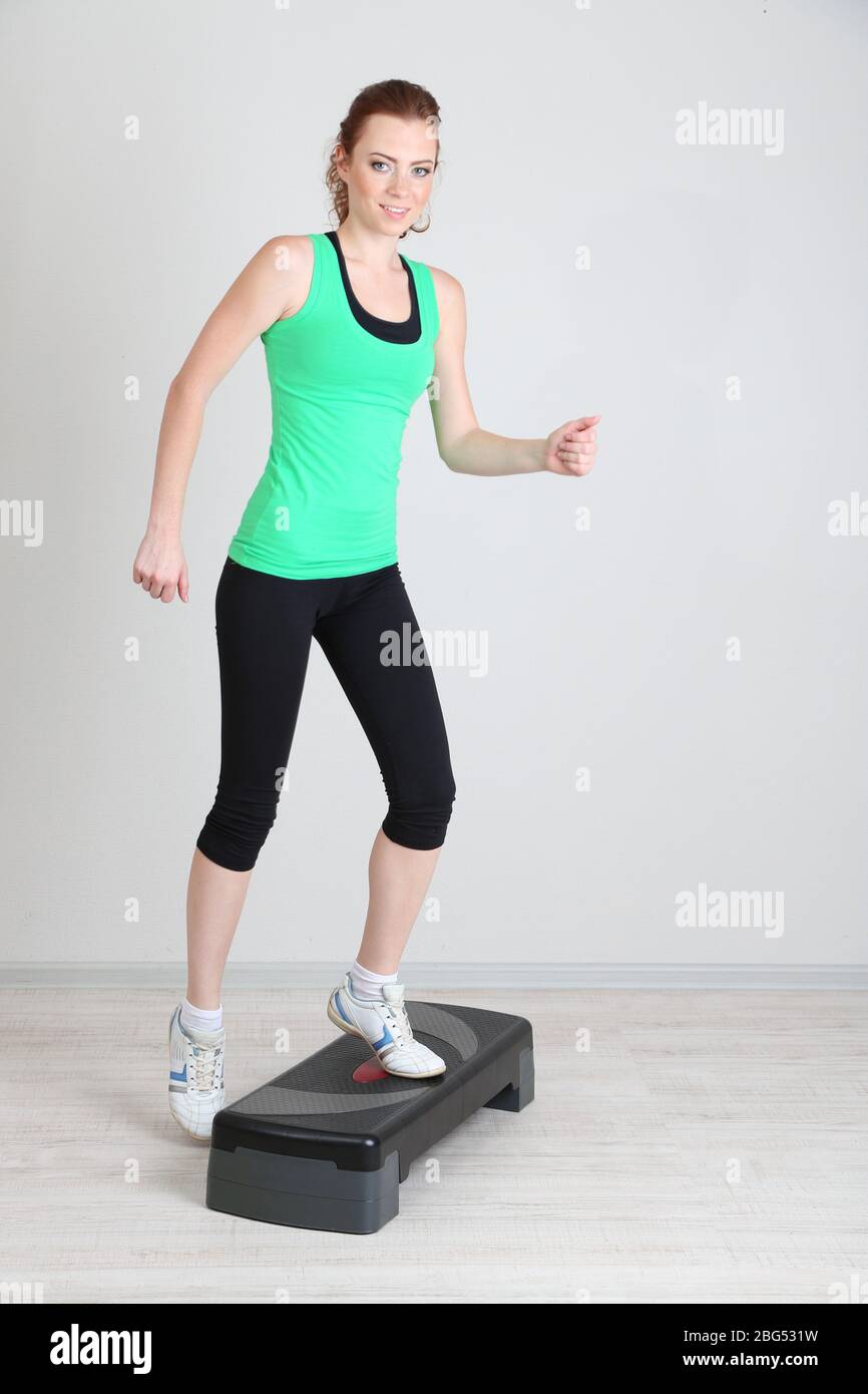 Beautiful young woman exercises on stepper Stock Photo - Alamy