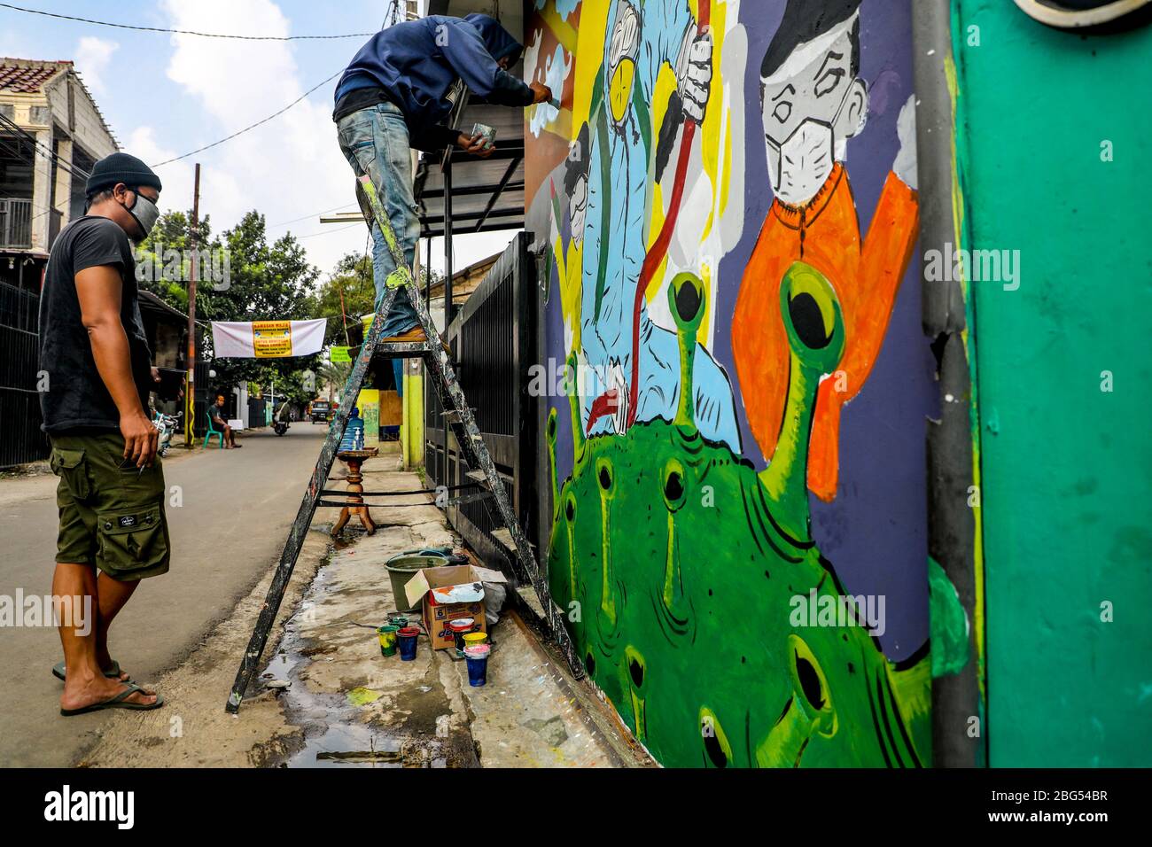 Yayak Kutil and his friend draw a coronavirus awareness graffiti on a ...