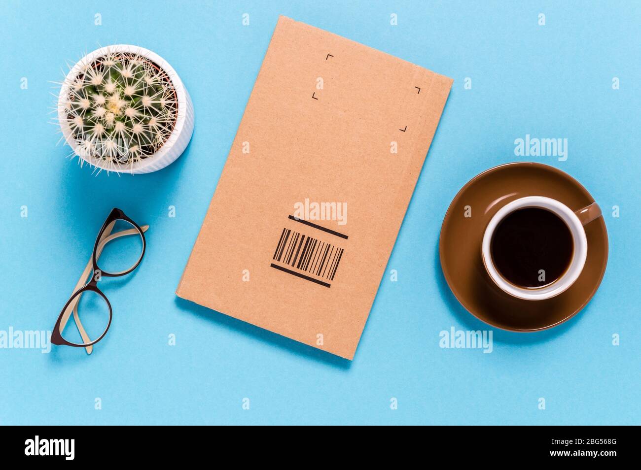 Flat lay with box package for sending, coffee cup, eyeglasses and ...