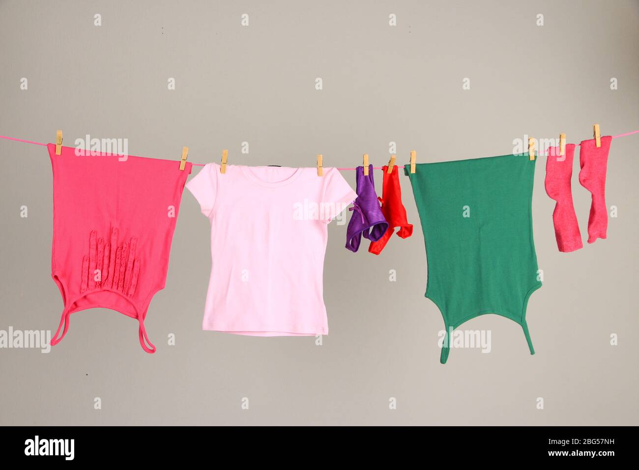 Laundry line with clothes on wall background Stock Photo - Alamy