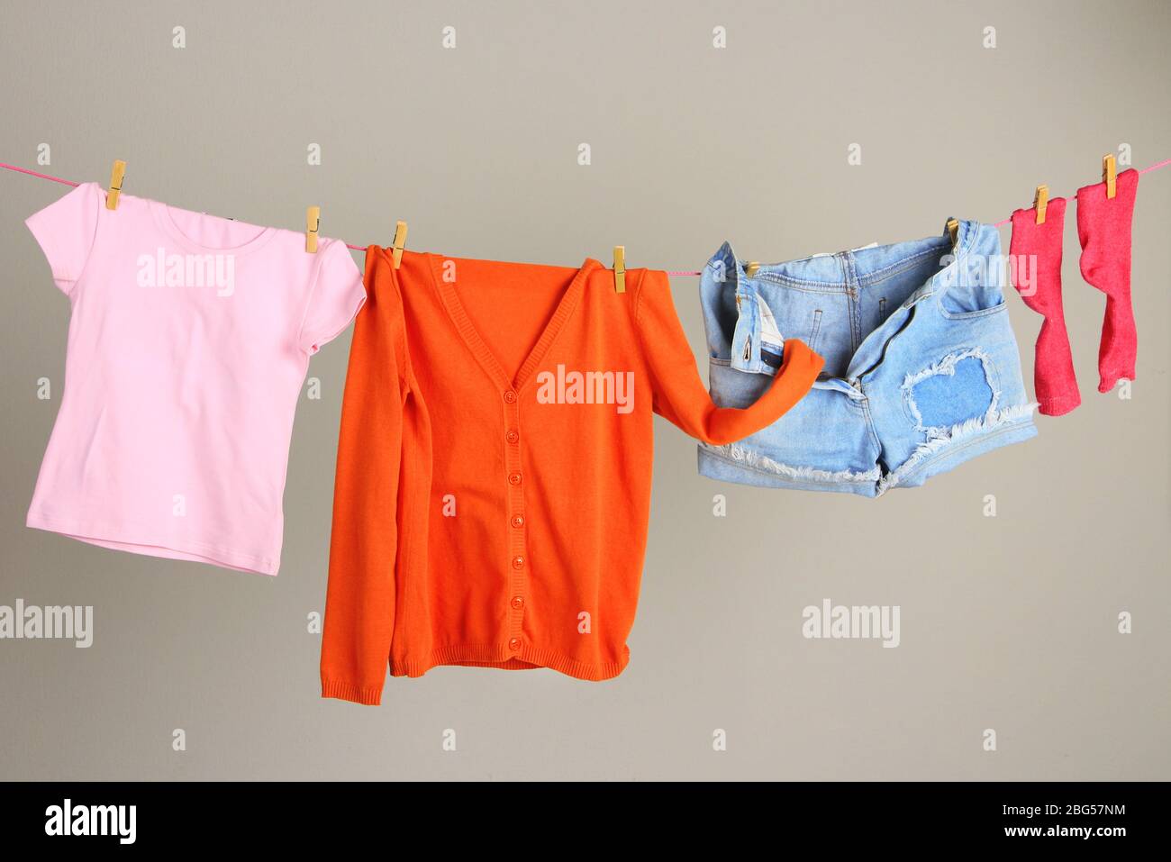 Laundry line with clothes on wall background Stock Photo - Alamy