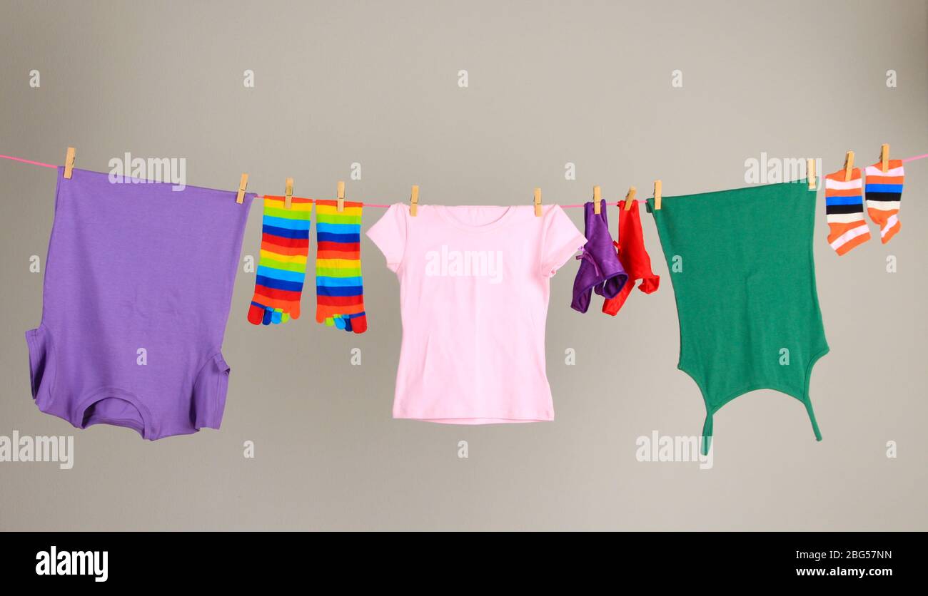 Laundry line with clothes on wall background Stock Photo - Alamy
