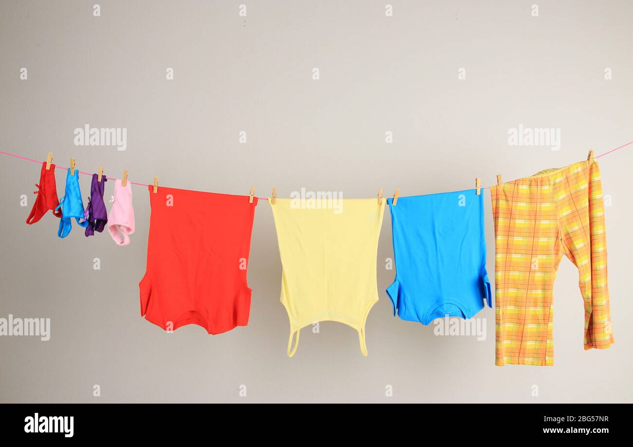 Laundry line with clothes on wall background Stock Photo - Alamy