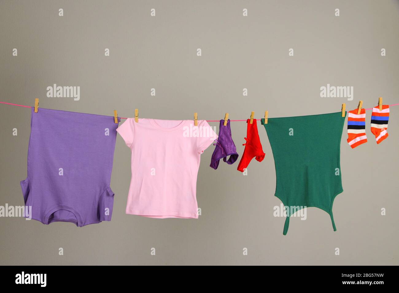 Laundry line with clothes on wall background Stock Photo - Alamy