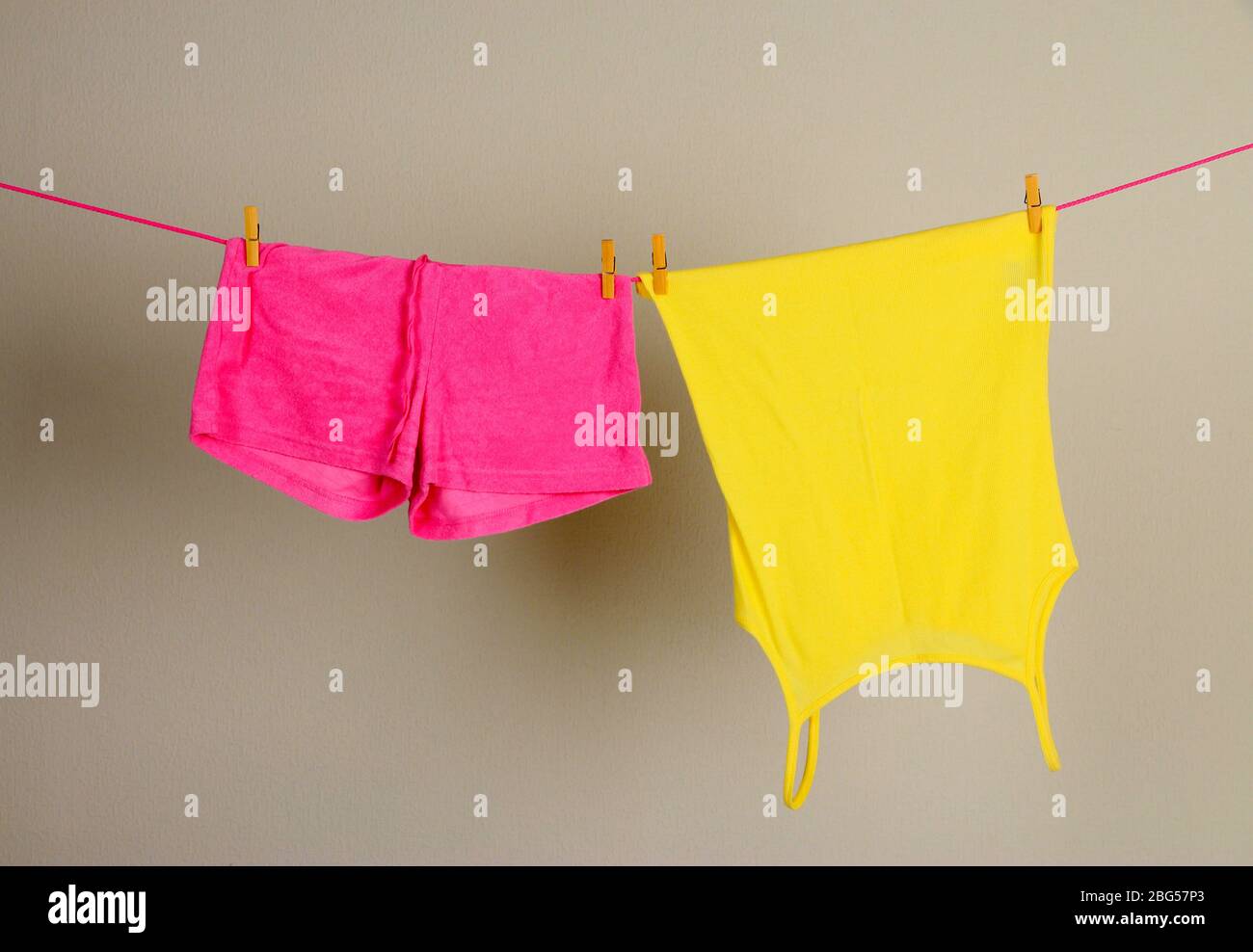 Laundry line with clothes on wall background Stock Photo - Alamy