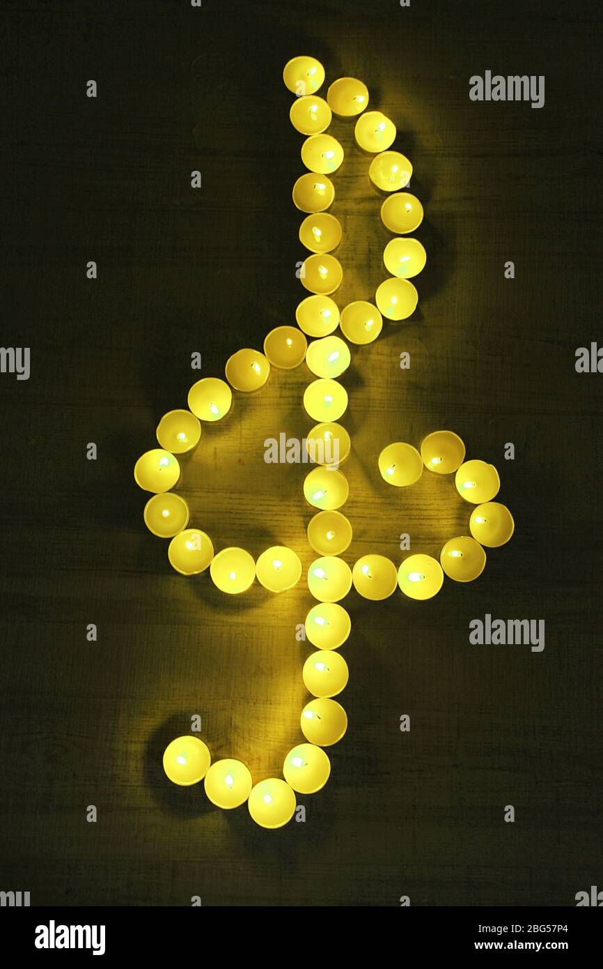 Burning candles as treble clef on dark background Stock Photo - Alamy